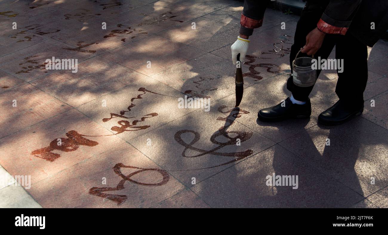 A man writing calligraphy on the ground in Shanghai, China Stock Photo ...