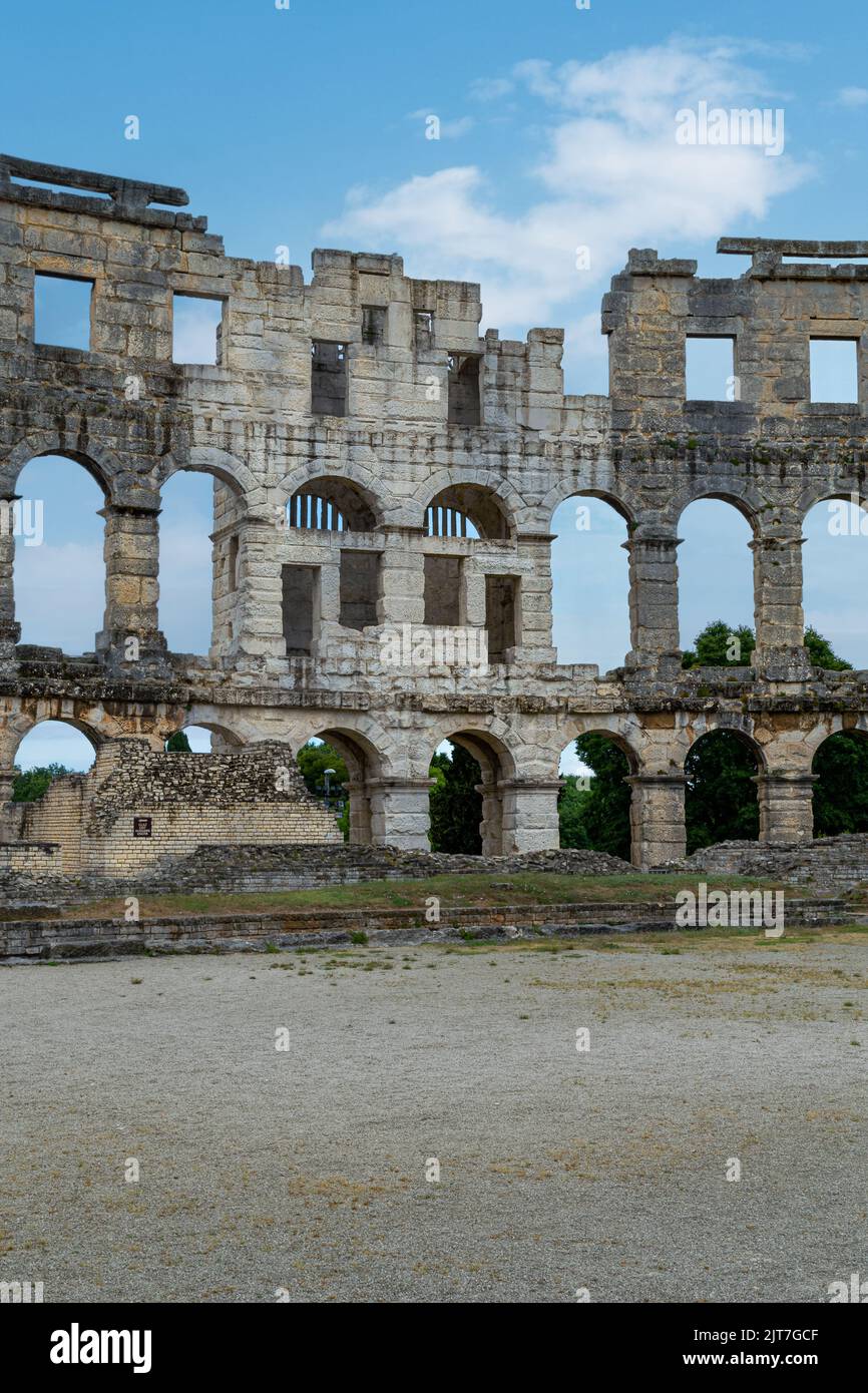 Pula's park-like setting is visible through the ancient arches of the ...