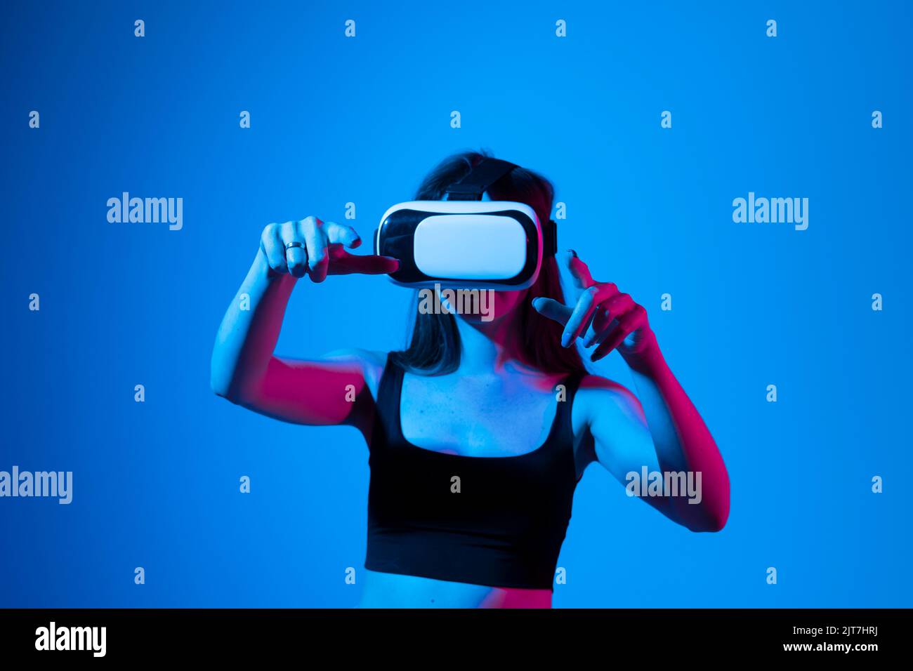 Brunette woman with VR headset touching something what she see in ...