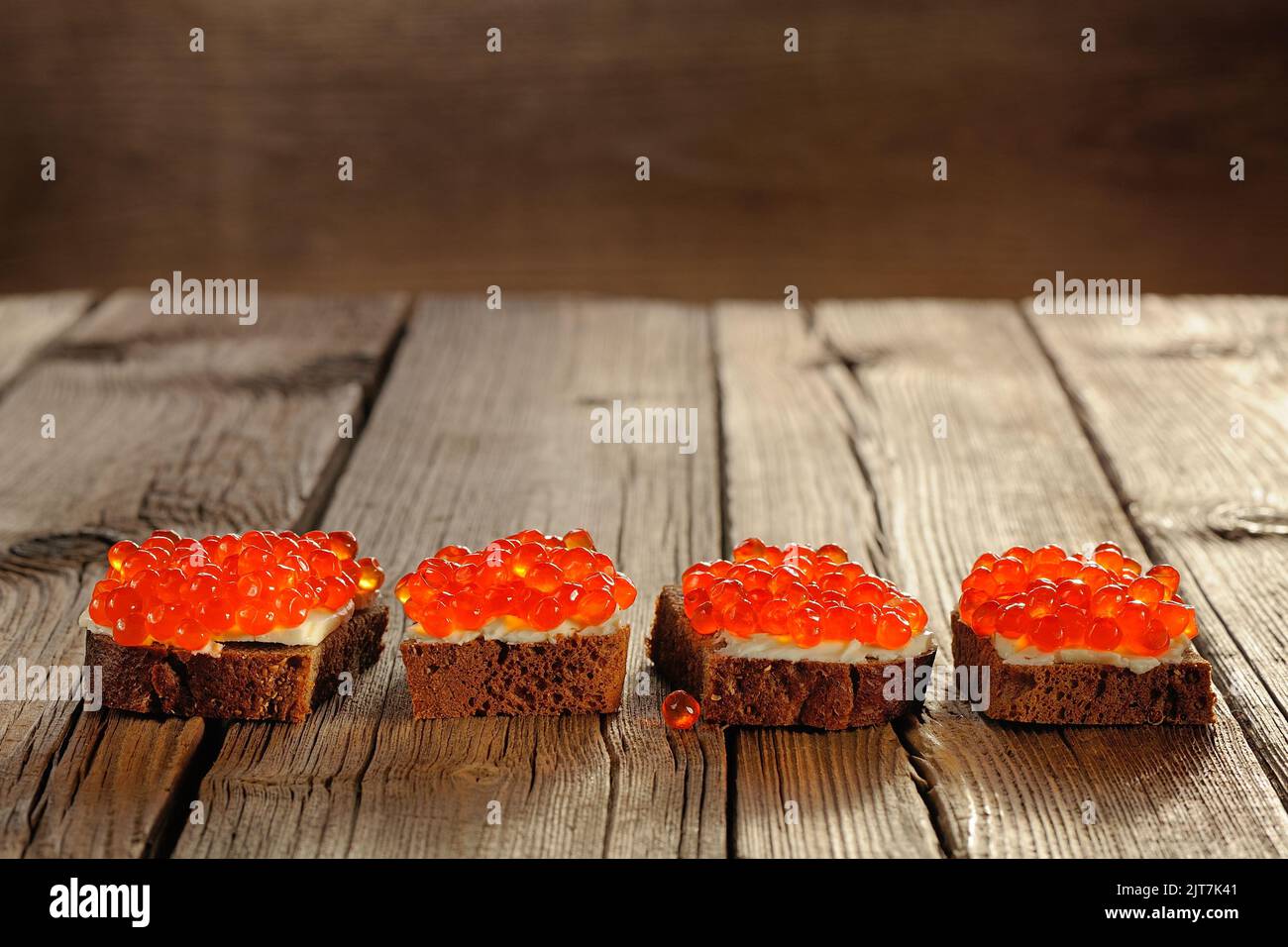Red caviar on rye bread and butter on wooden background Stock Photo - Alamy