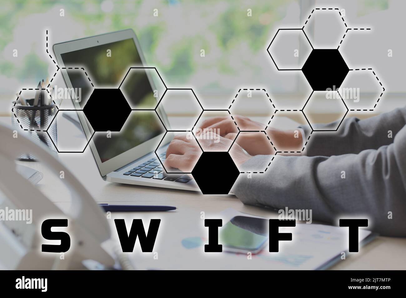 Businessman with laptop in office and virtual screen with word SWIFT ...