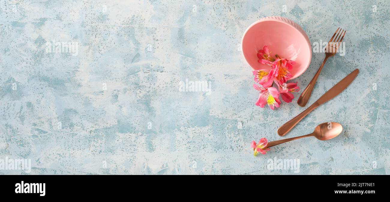 Table setting with beautiful flowers on blue background with space for ...