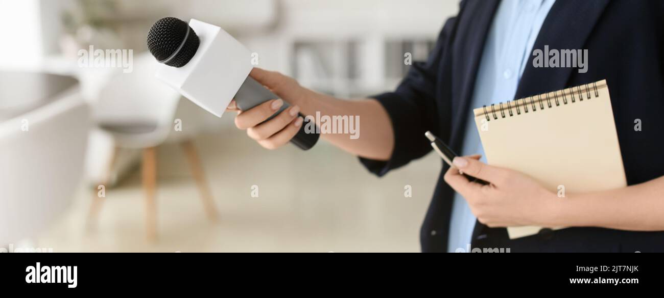 Female journalist with microphone interviewing guest in studio Stock Photo - Alamy