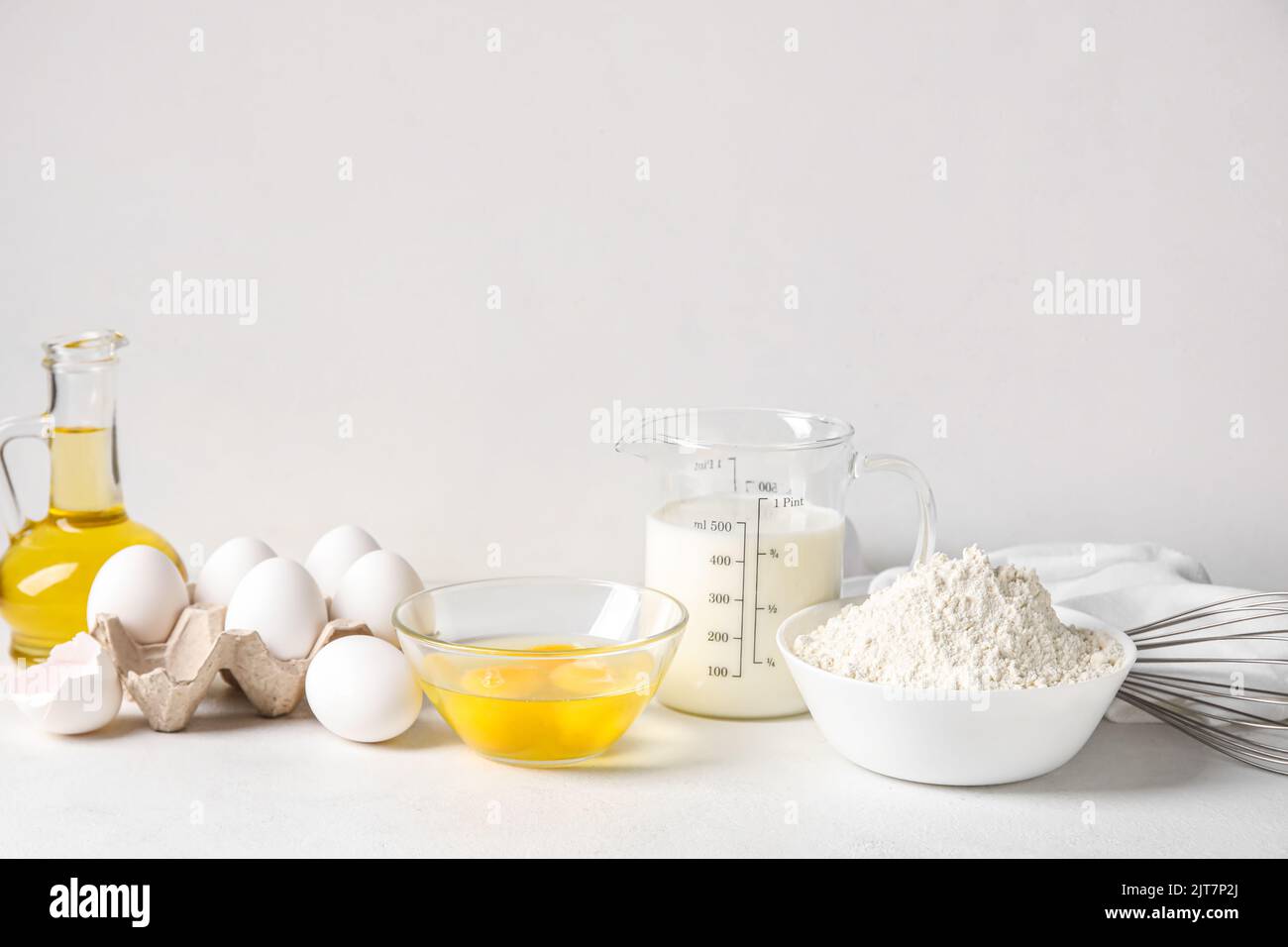 Different ingredients for baking on table against white background ...