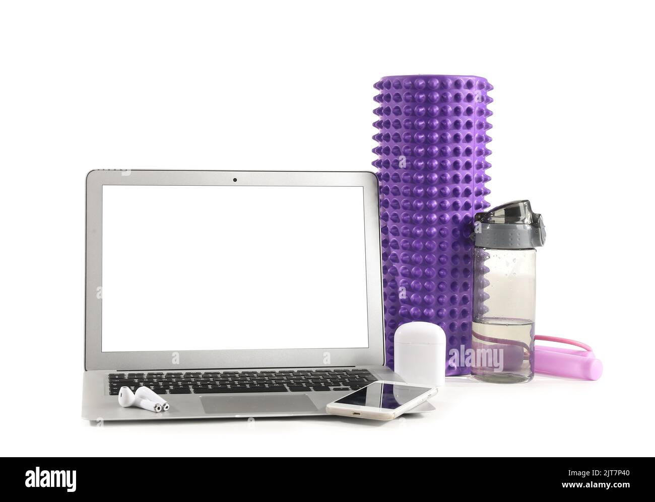 Foam roller, bottle of water, laptop, mobile phone and earphones on ...