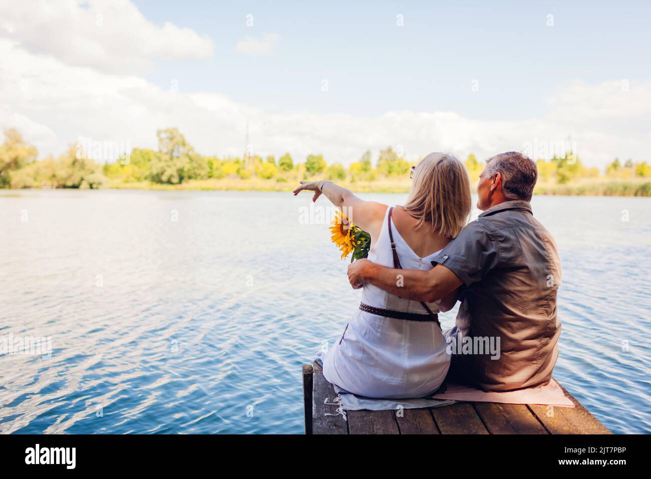 Senior family couple relaxing by summer river. Man and woman enjoying ...