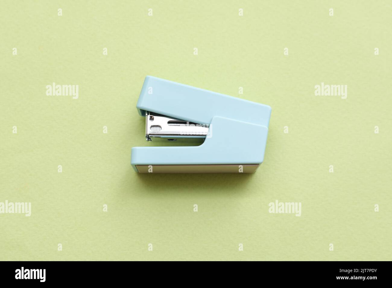 Blue stapler on green background Stock Photo - Alamy