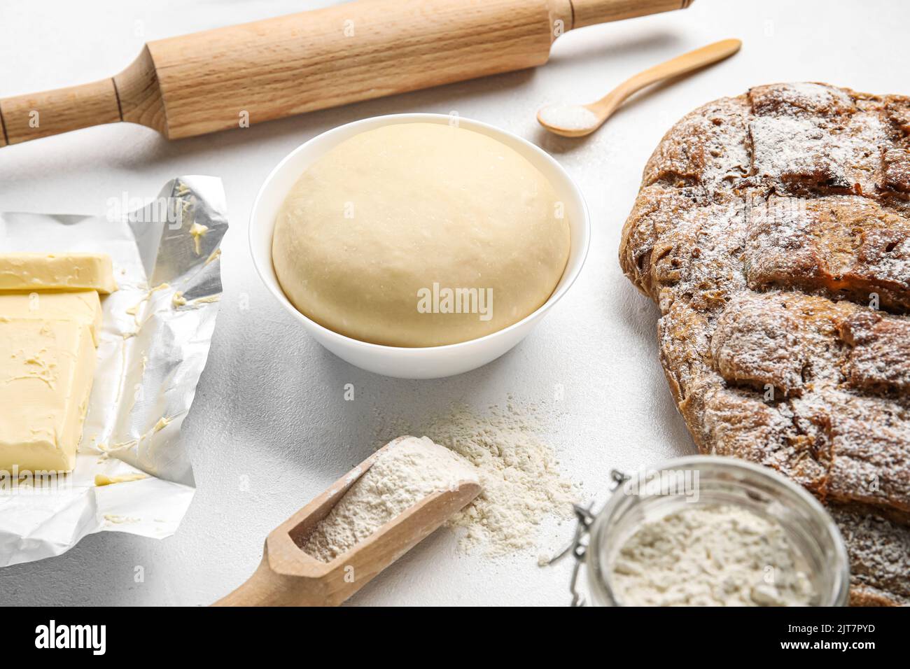 Fresh rye bread with raw dough, ingredients and utensils on white ...