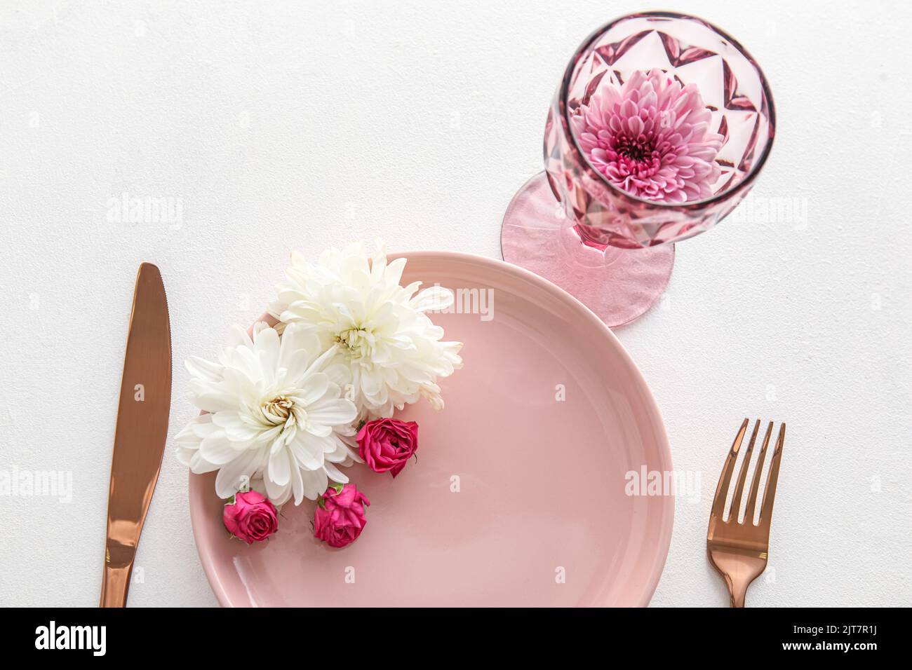 Beautiful table setting with chrysanthemum flowers and roses on white ...