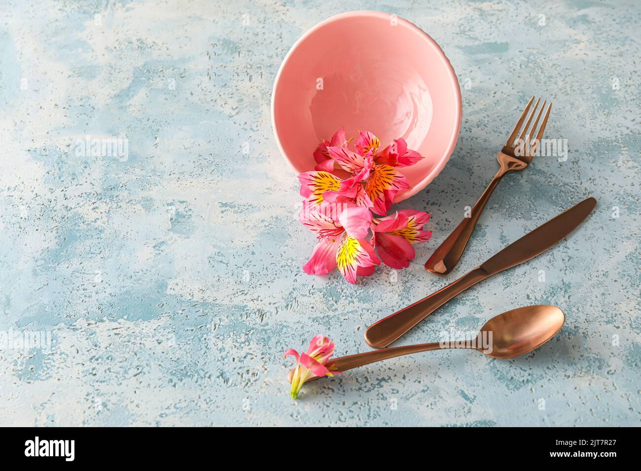 Table setting with beautiful alstroemeria flowers on blue background ...