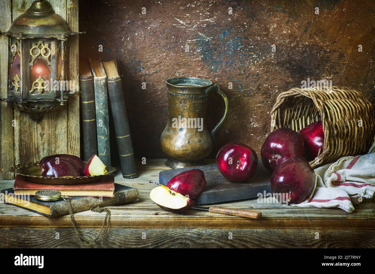 Classic still life with fresh red apples placed with antique jar and ...