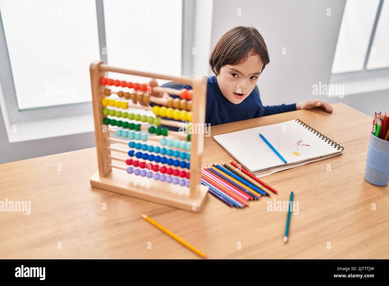 Down syndrome kid drawing on notebook at school Stock Photo - Alamy