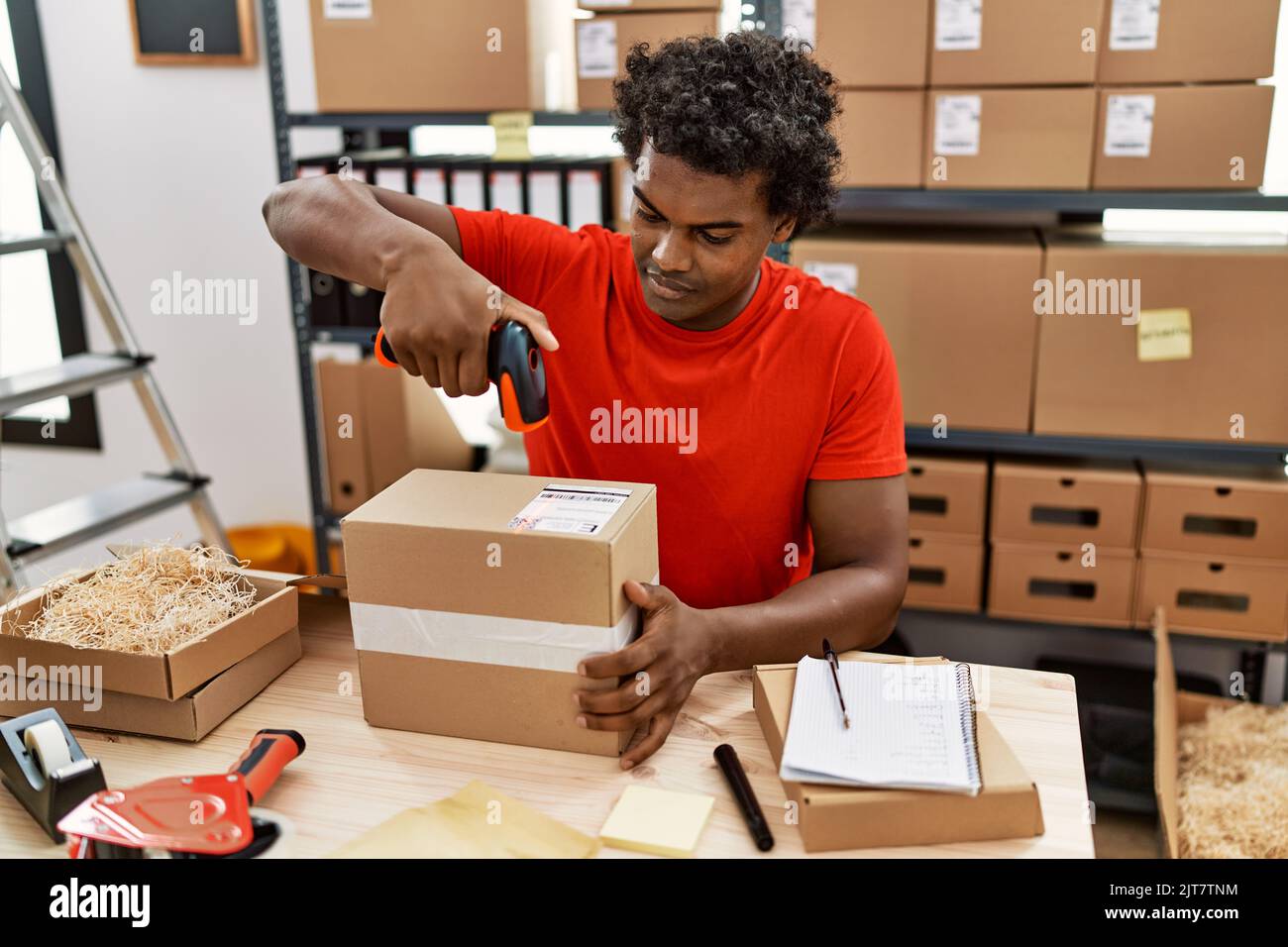 Young south east man using barcode reader device working at storehouse ...