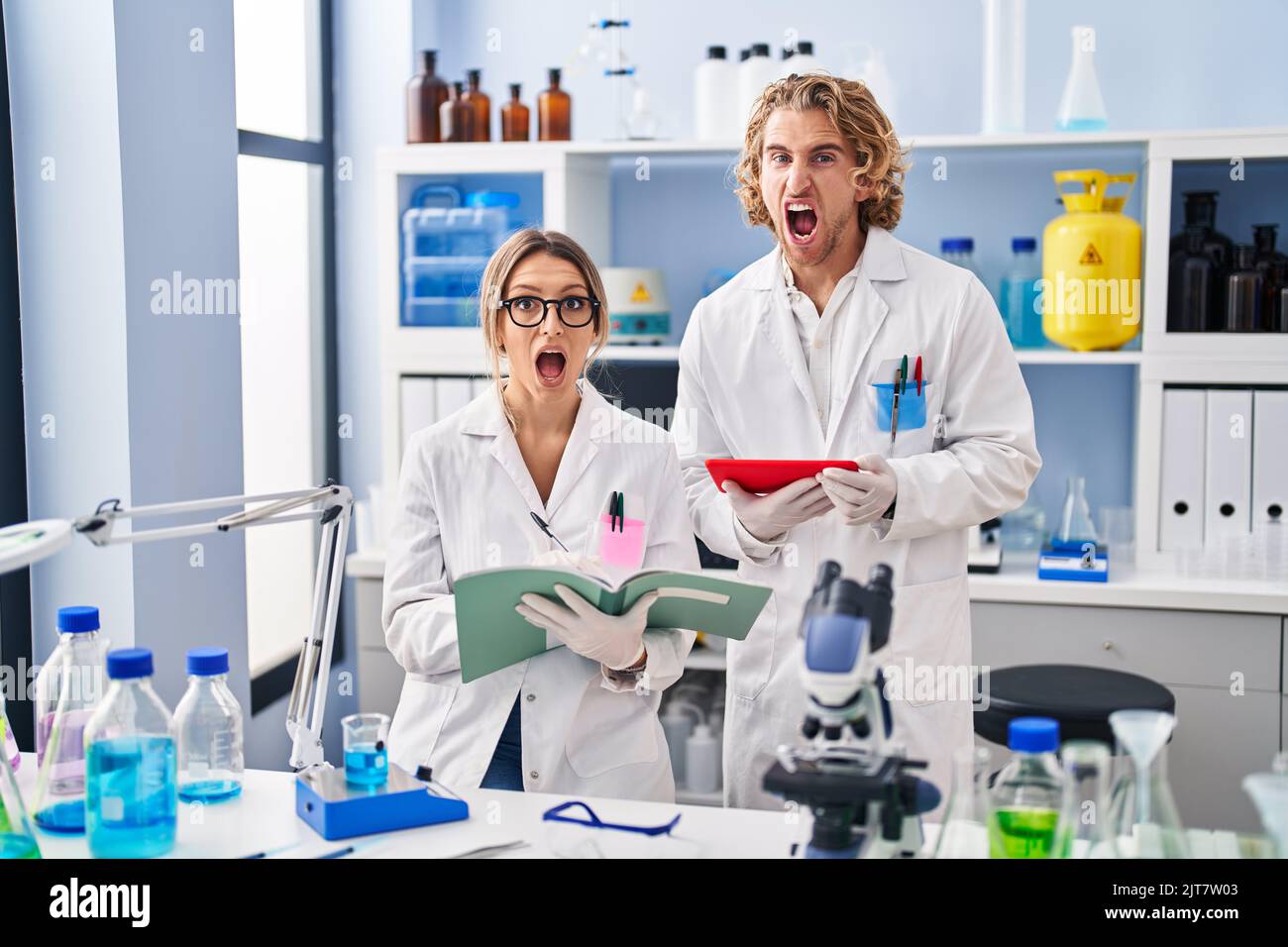 Two people working at scientist laboratory angry and mad screaming ...