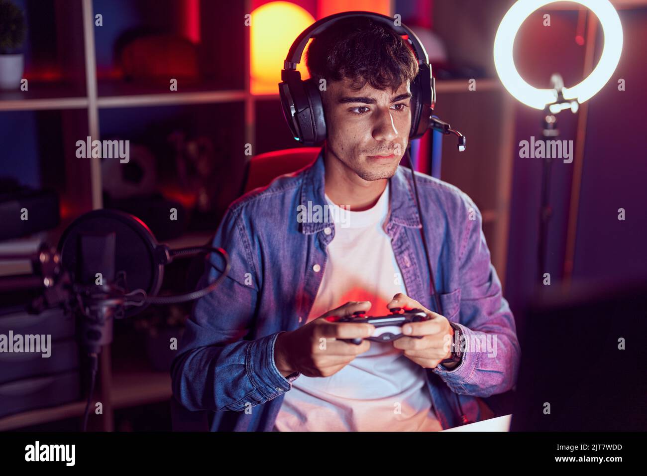 Young hispanic man streamer playing video game using joystick at gaming ...