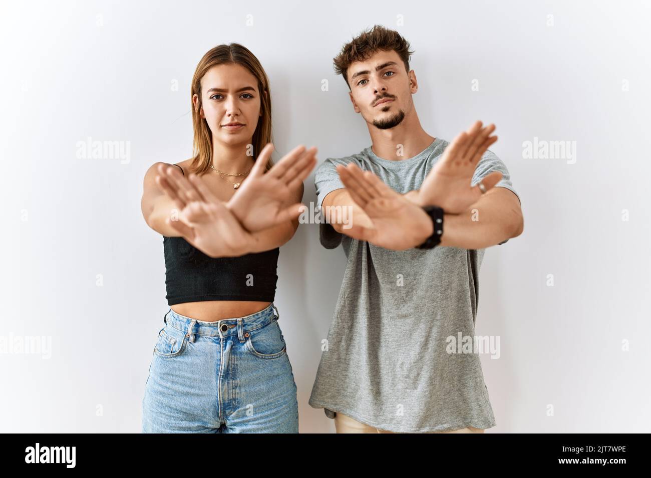 Young beautiful couple standing together over isolated background ...