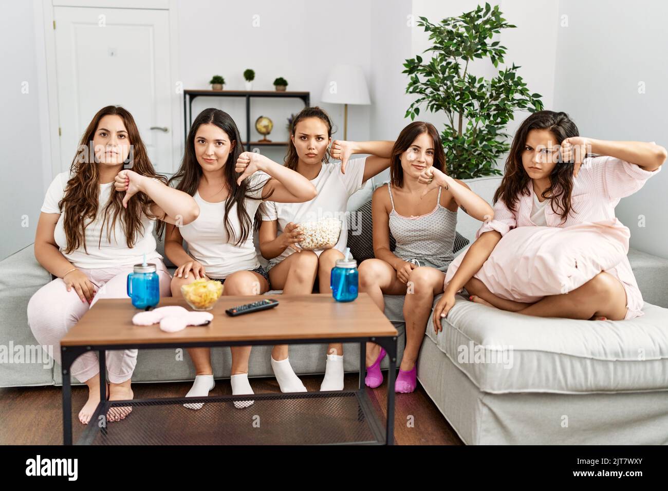 Group of women celebrating pajamas party at home with angry face ...