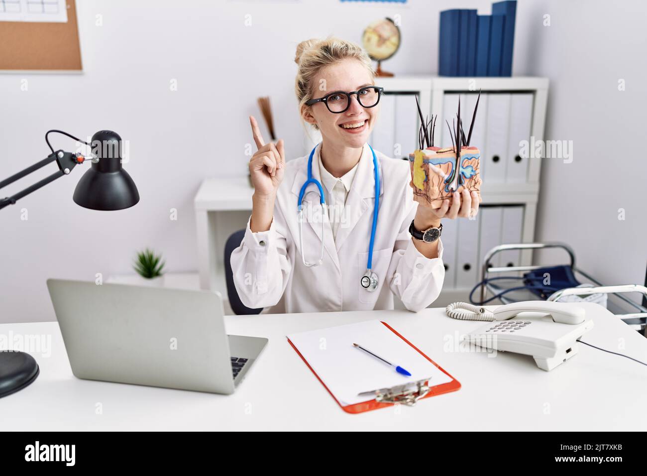 Young doctor woman holding model of human anatomical skin and hair at ...