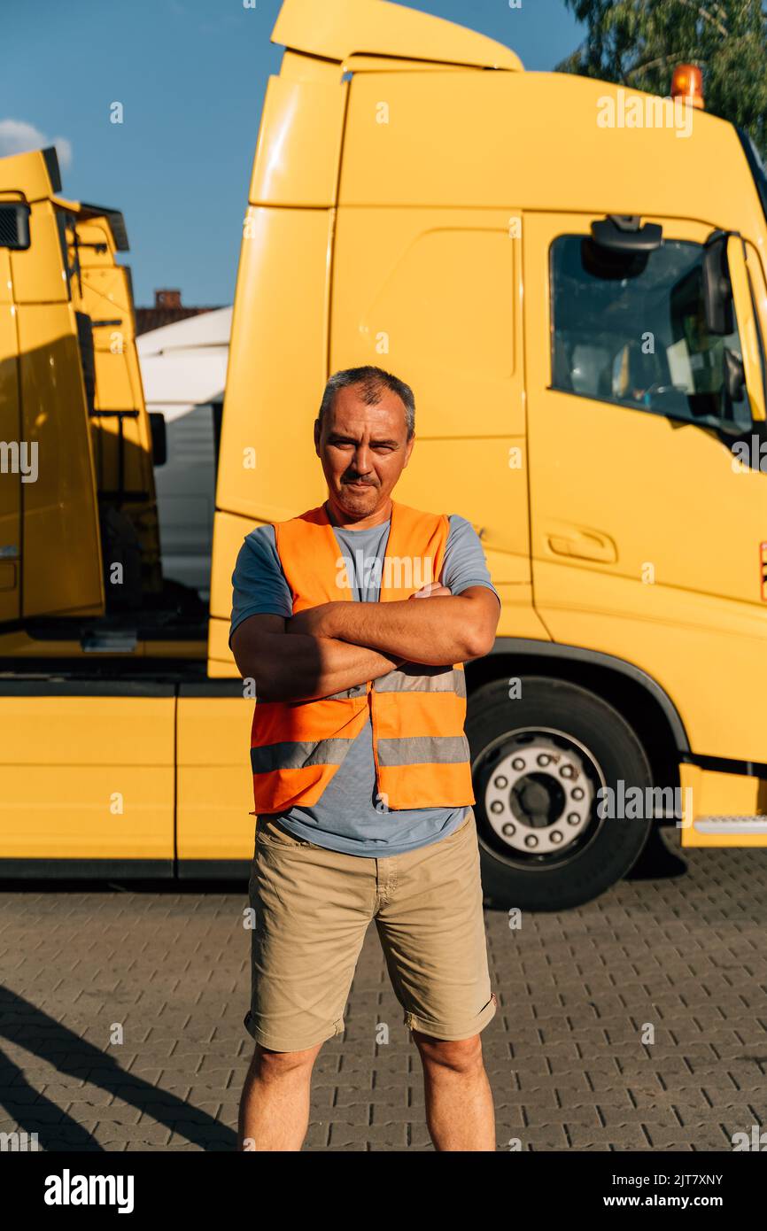 Portrait of caucasian mature man on semi-truck vehicles parking ...