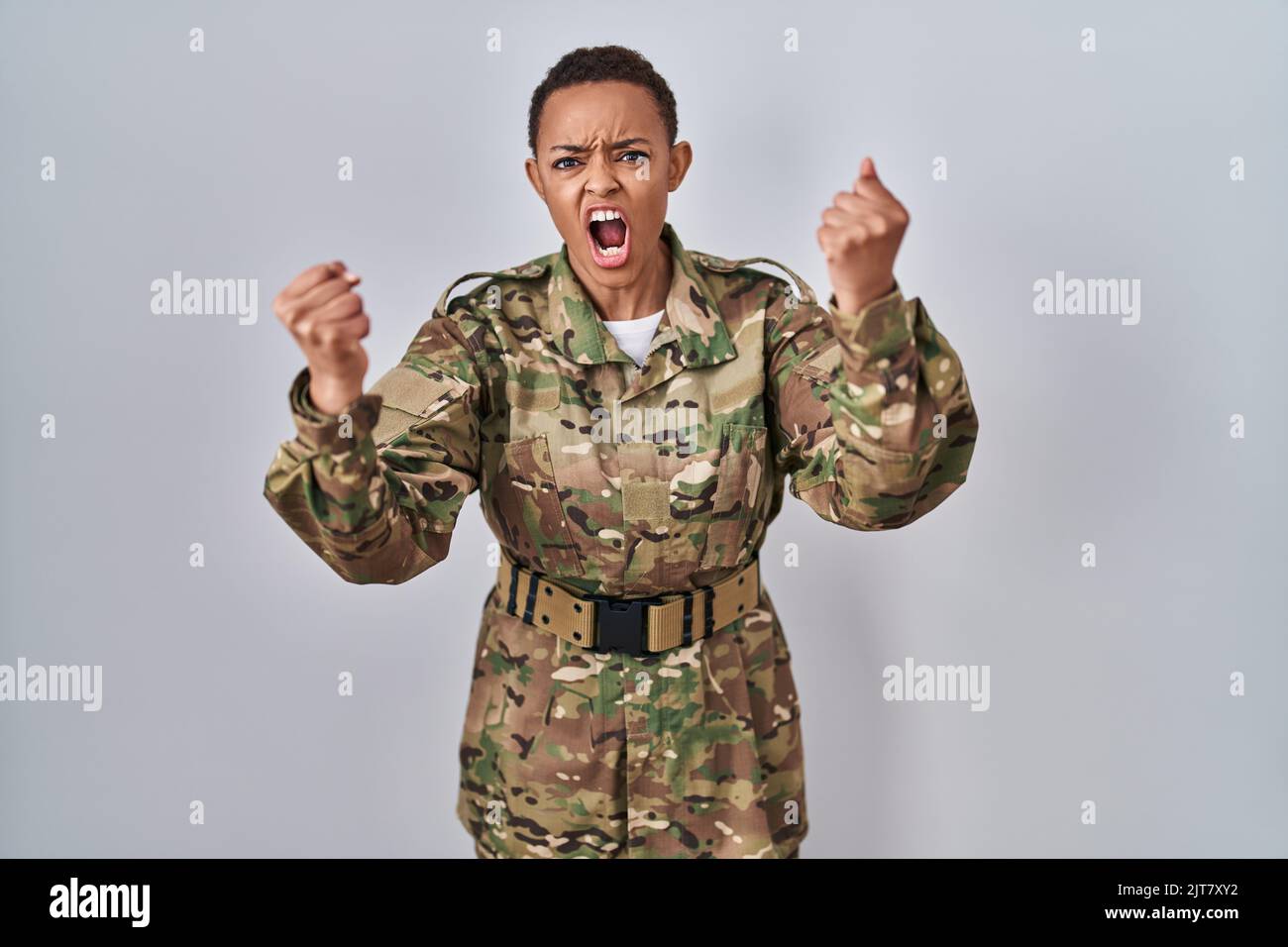 Beautiful african american woman wearing camouflage army uniform angry ...