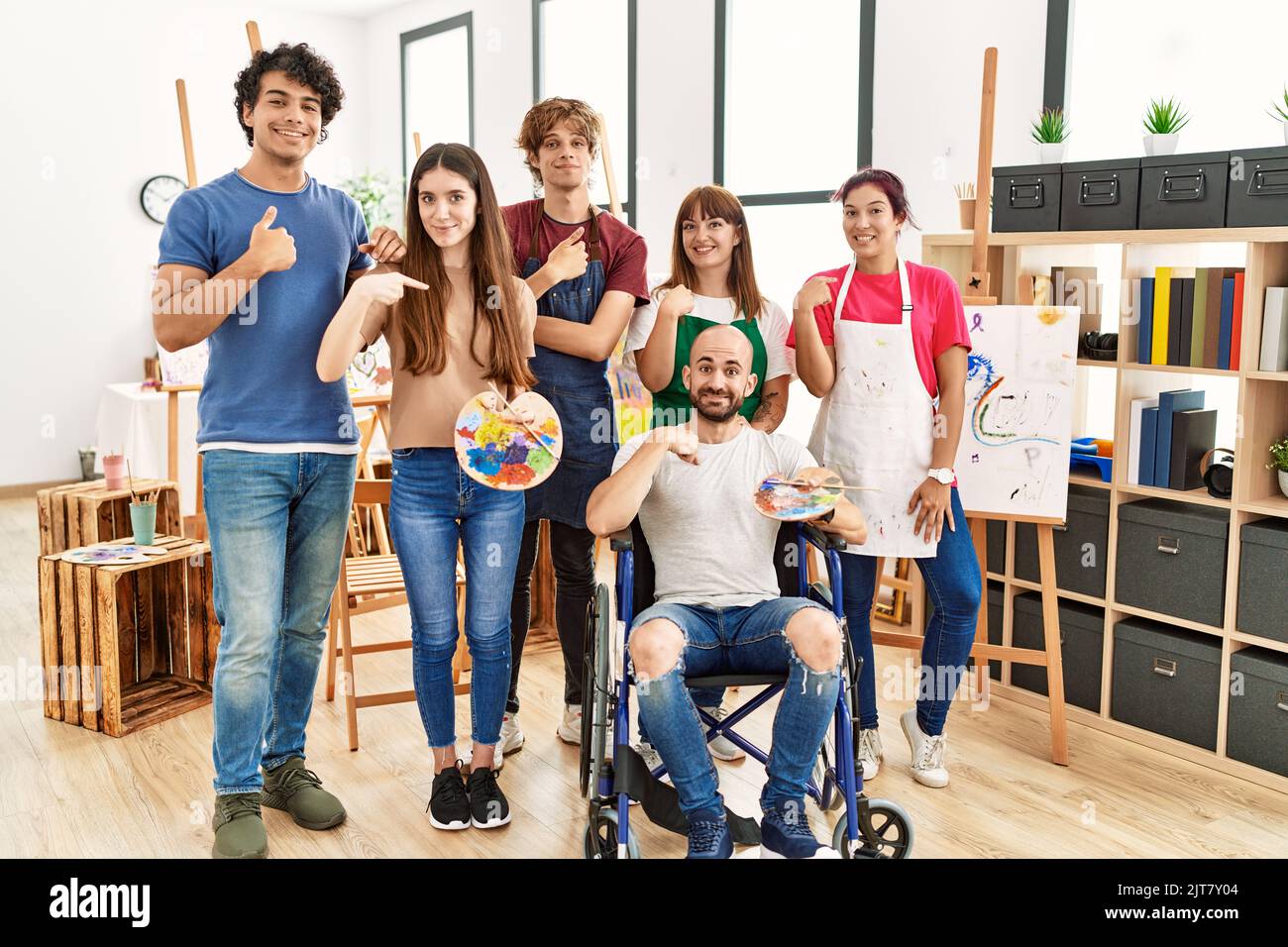 Group of young artists people at art studio pointing finger to one self ...