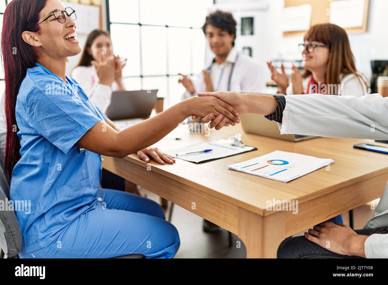 Group of doctor smiling and clapping to partners handshake in a medical ...