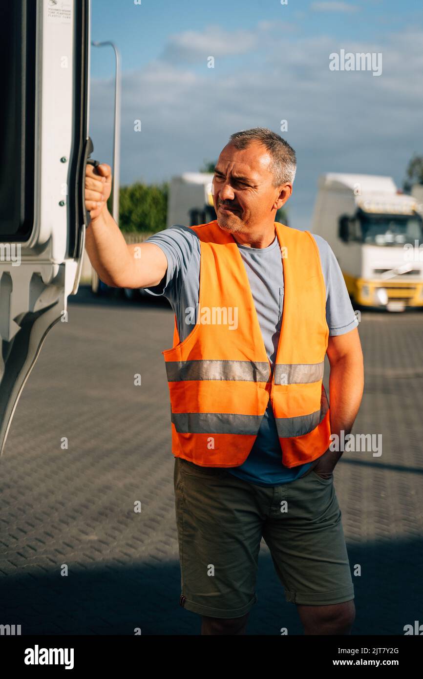 Portrait of caucasian mature man on semi-truck vehicles parking ...