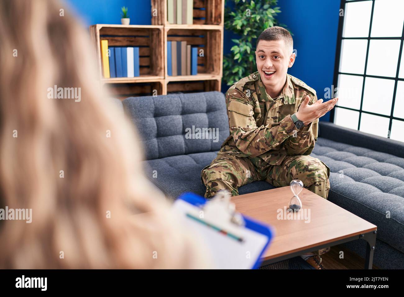 Young man doing therapy after war pointing aside with hands open palms ...