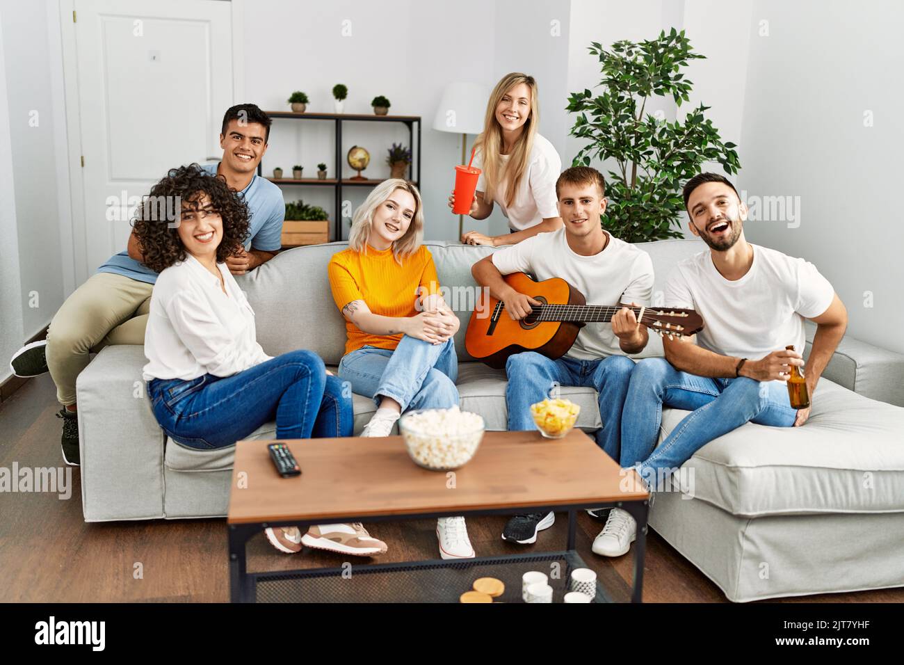 Group of young friends on party smiling happy and playing classical ...