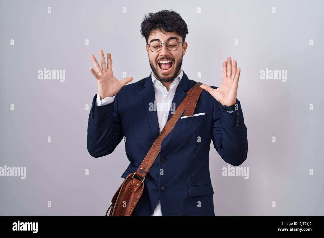 Hispanic man with beard wearing business clothes celebrating mad and ...