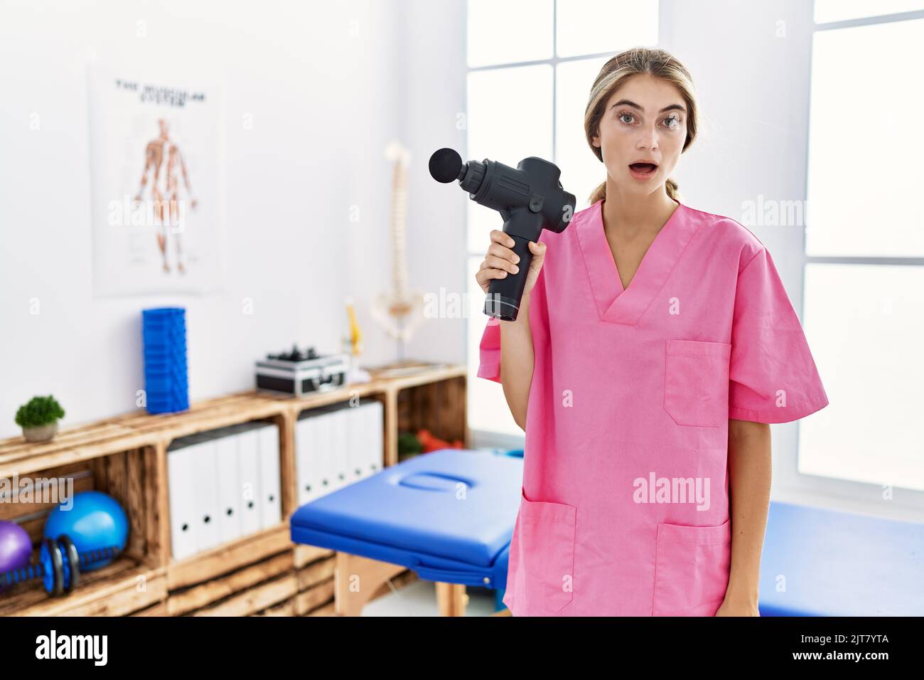 Young Physiotherapist Woman Holding Therapy Massage Gun At Wellness