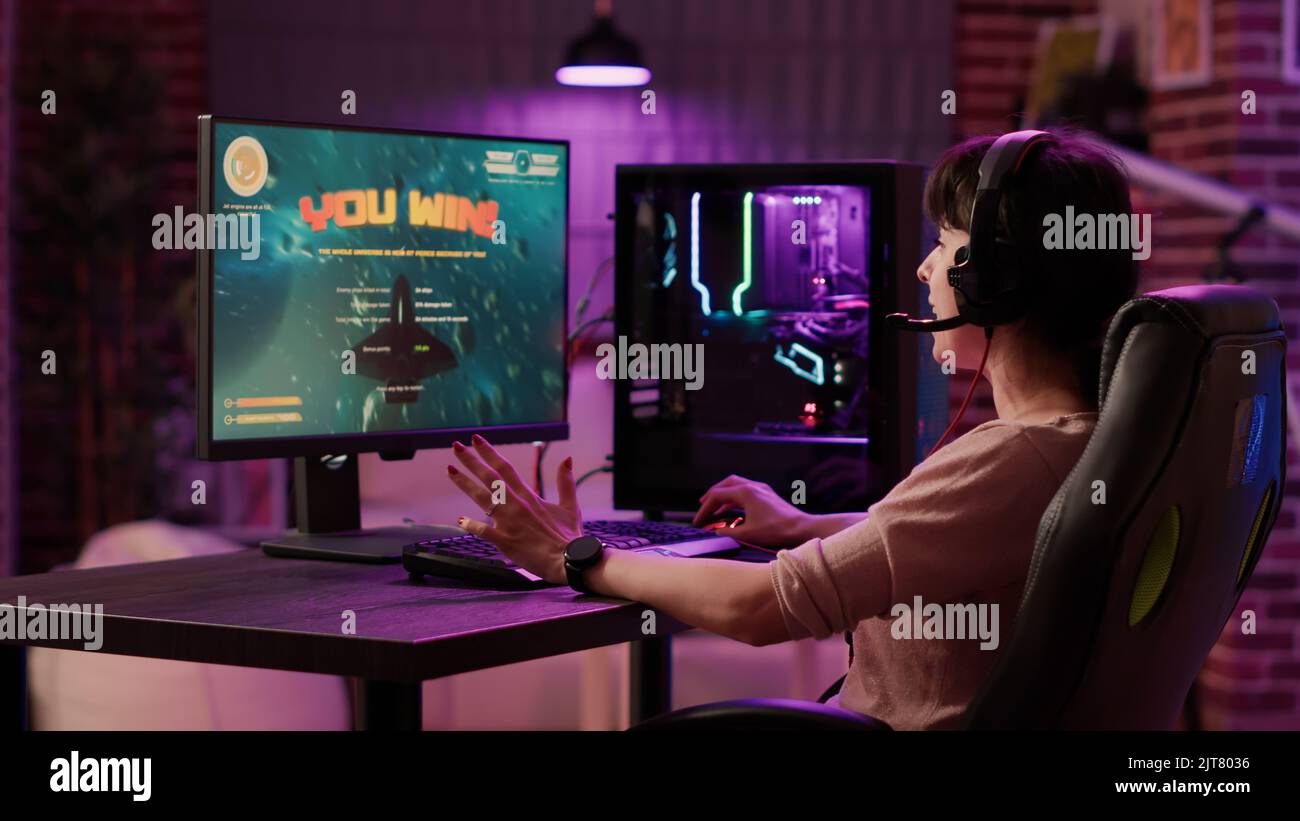 Gamer girl celebrating winning first place in space shooter online ...