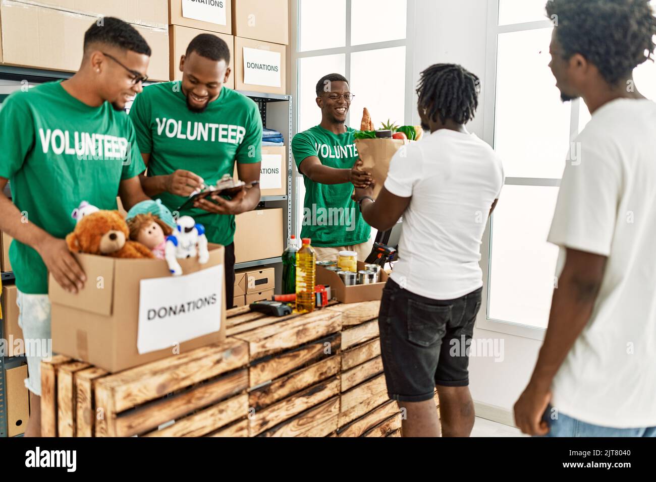 Group of young african american volunteers helping people at charity ...