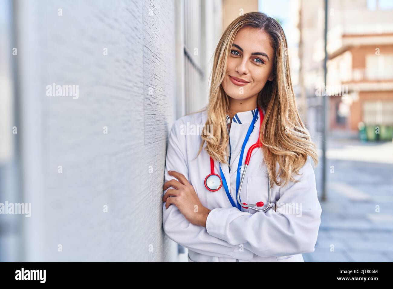 Young blonde woman wearing doctor uniform standing at hospital Stock ...