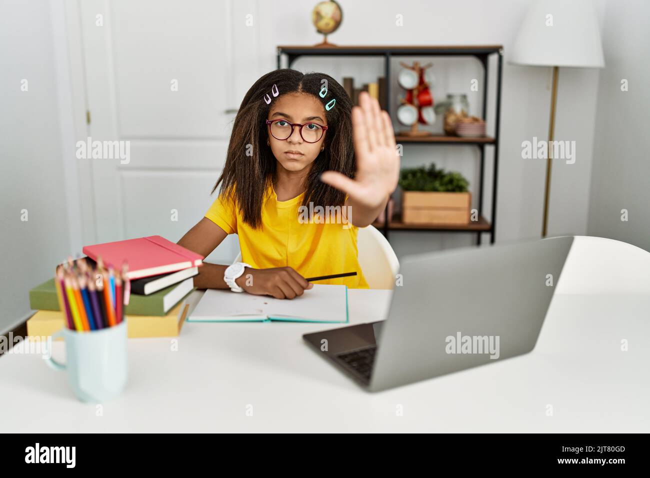 Young african american girl doing homework at home doing stop sing with ...