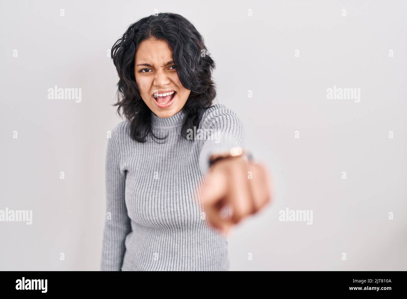 Hispanic woman with dark hair standing over isolated background ...
