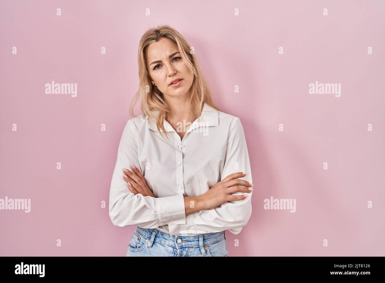 Young caucasian woman wearing casual white shirt over pink background ...