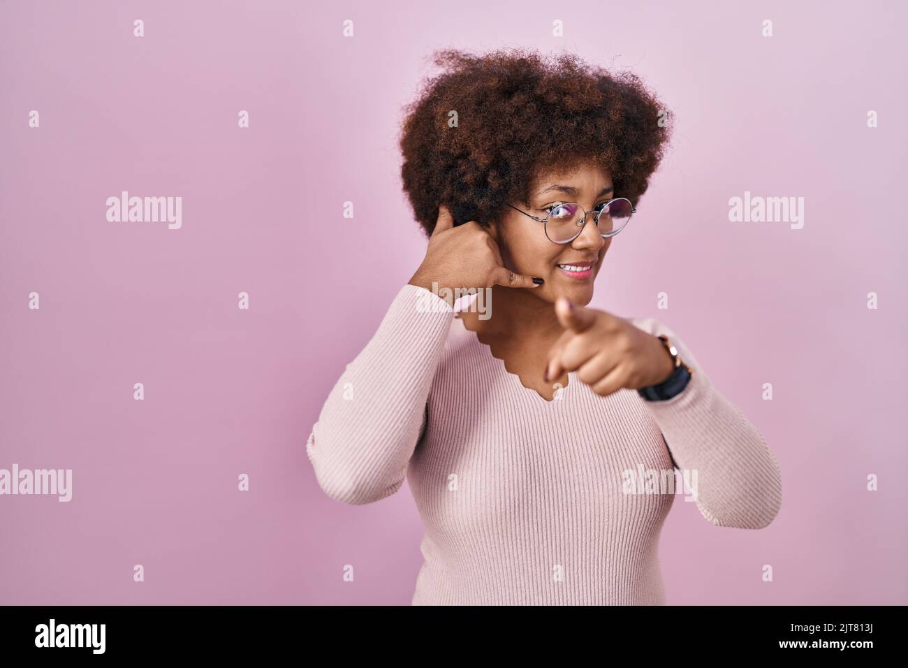Young african american woman standing over pink background smiling ...