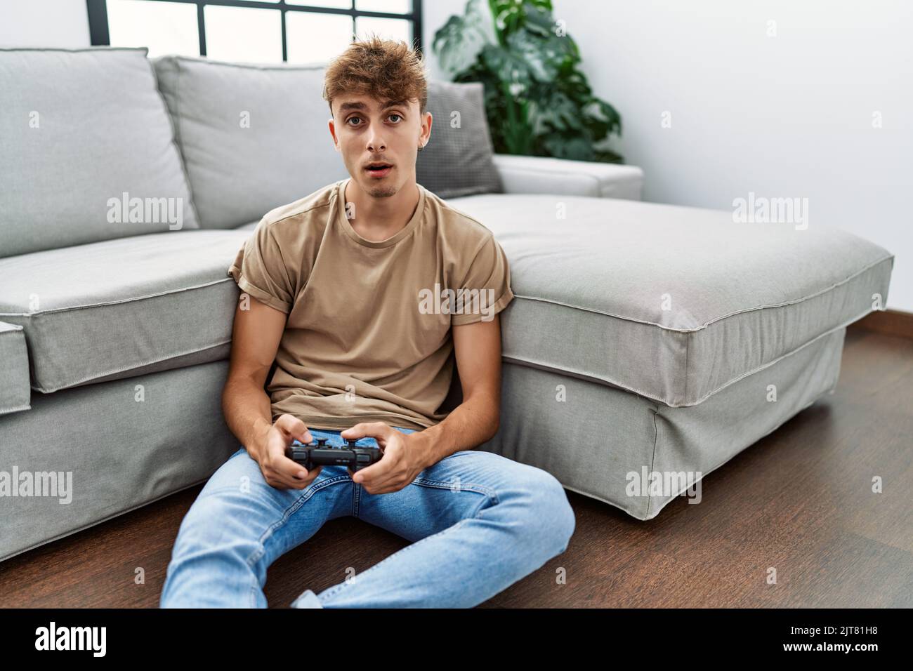 Young caucasian man playing video game holding controller at home ...