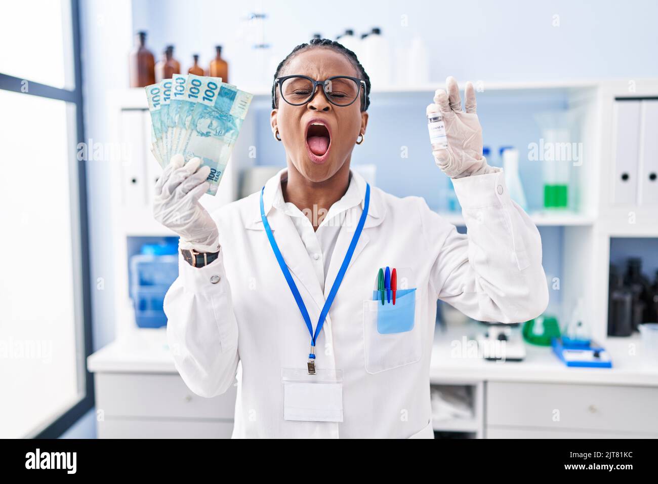 African woman with braids working at scientist laboratory holding money ...