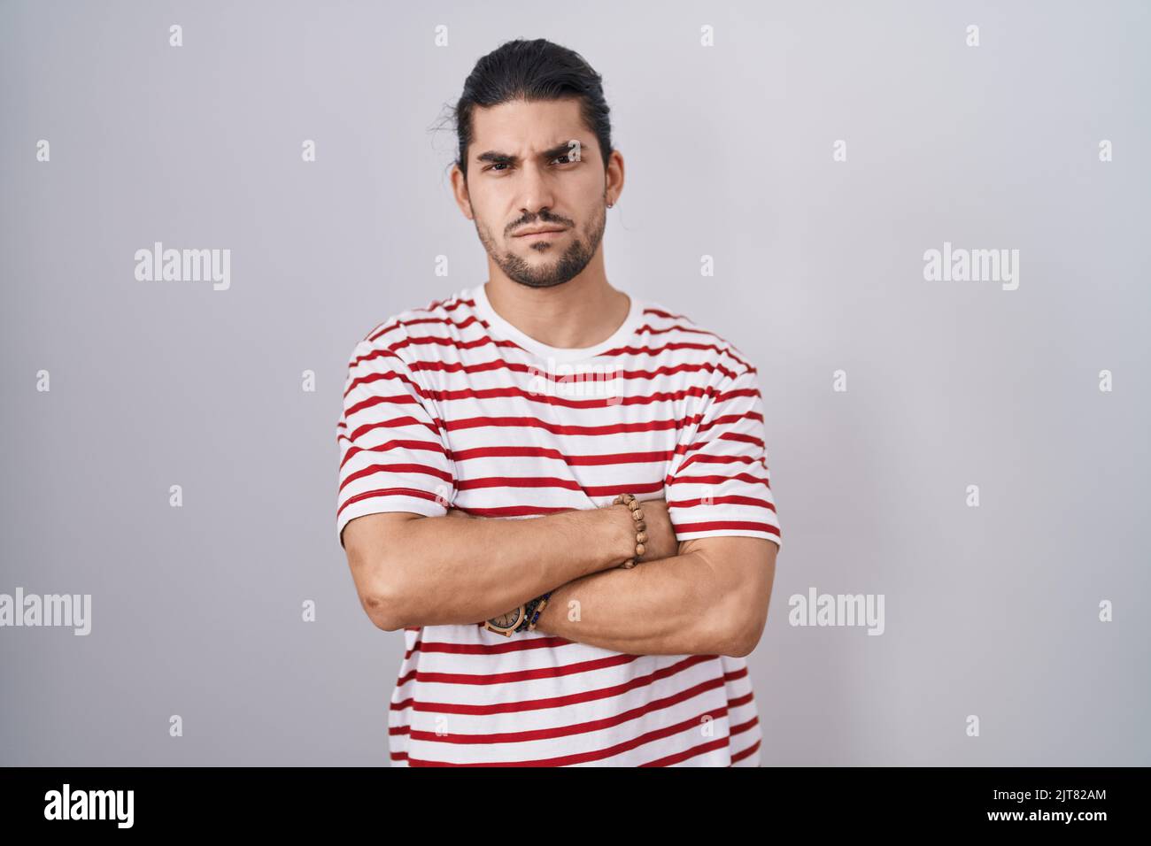 Hispanic man with long hair standing over isolated background skeptic ... Hispanic man with long hair standing over isolated background skeptic ...