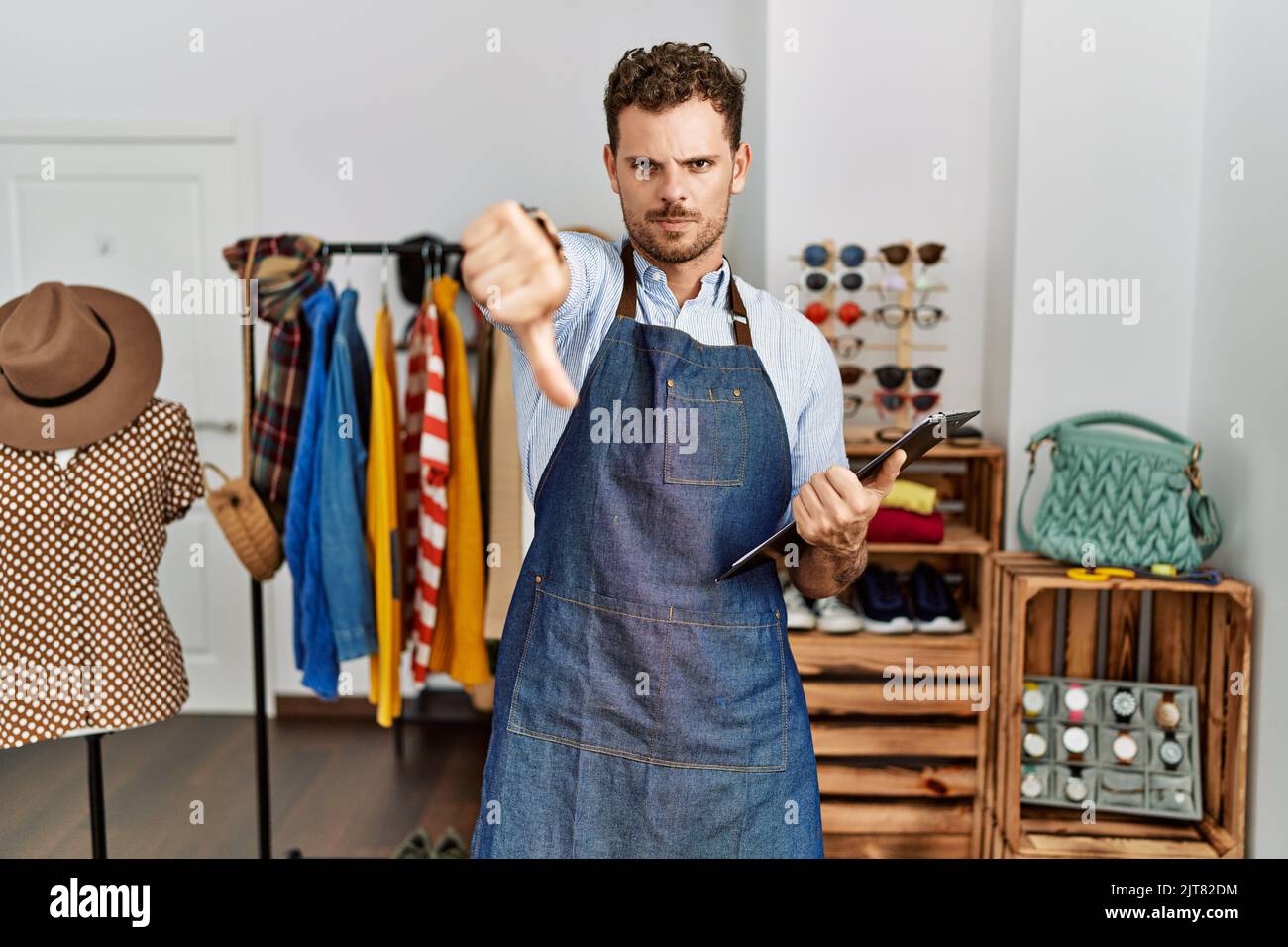 Handsome young man working as manager at retail boutique looking ...
