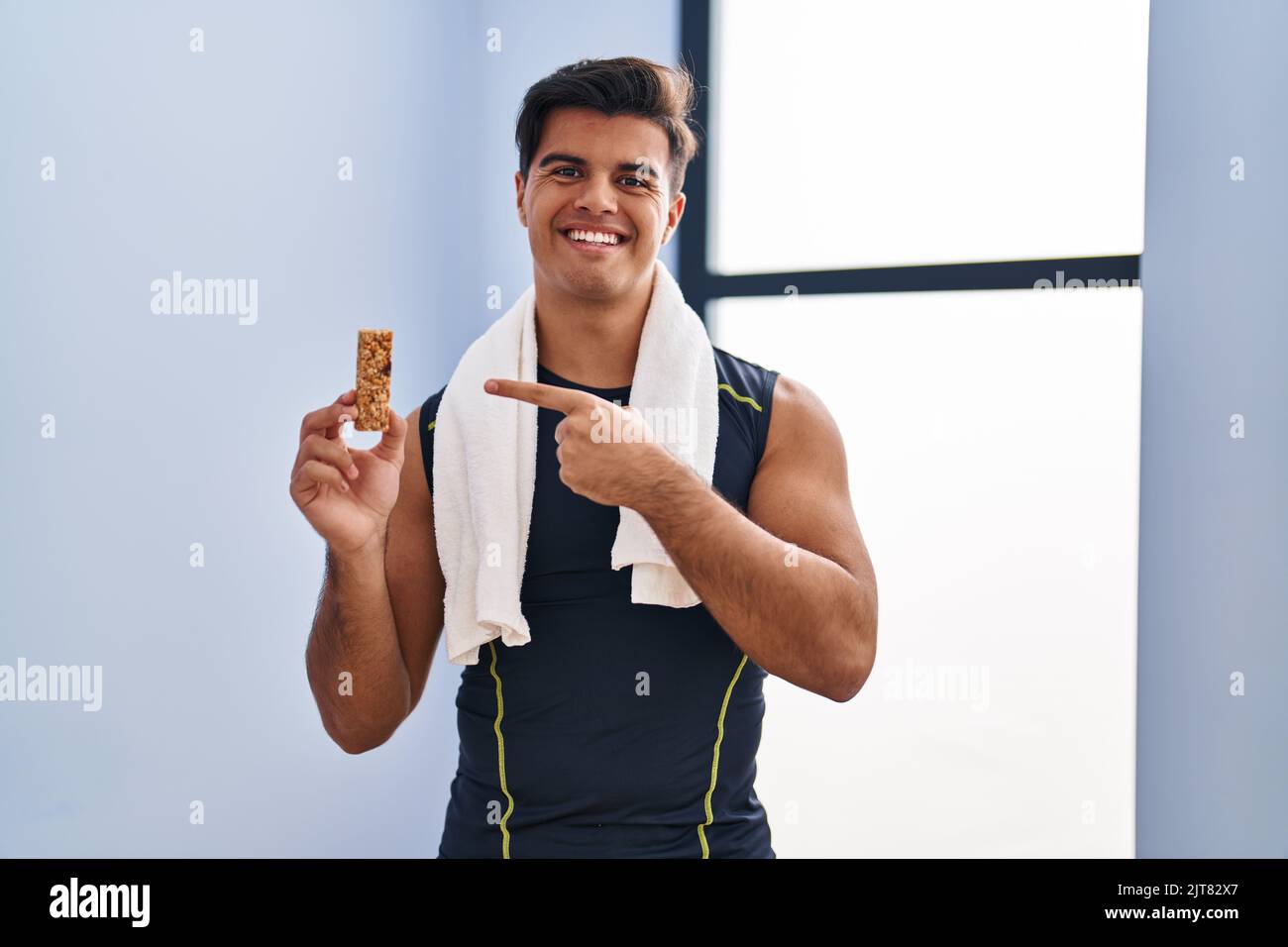Hispanic man eating protein bar as healthy energy snack smiling happy ...