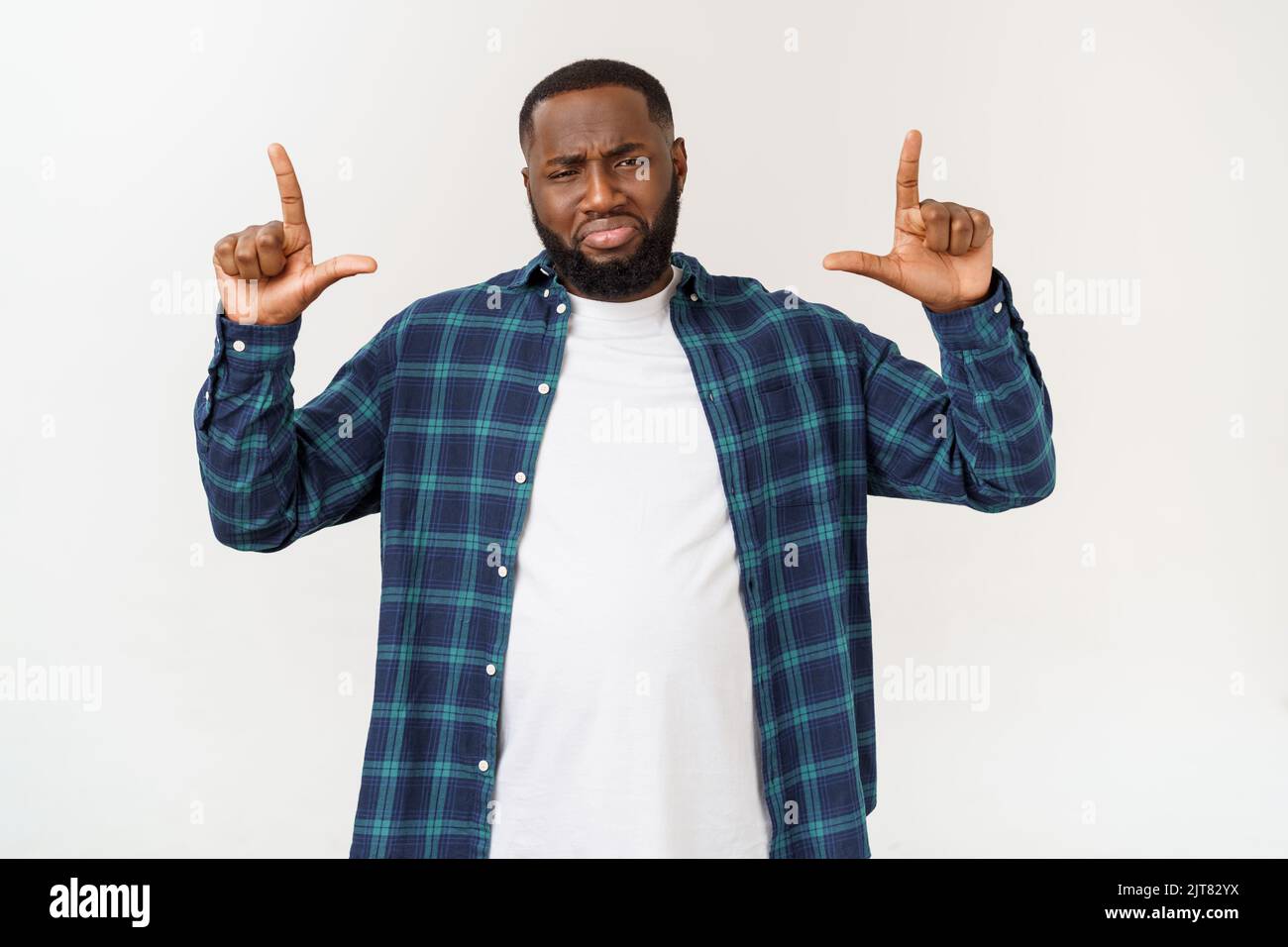 Young amazed African American pointing his finger at white background ...