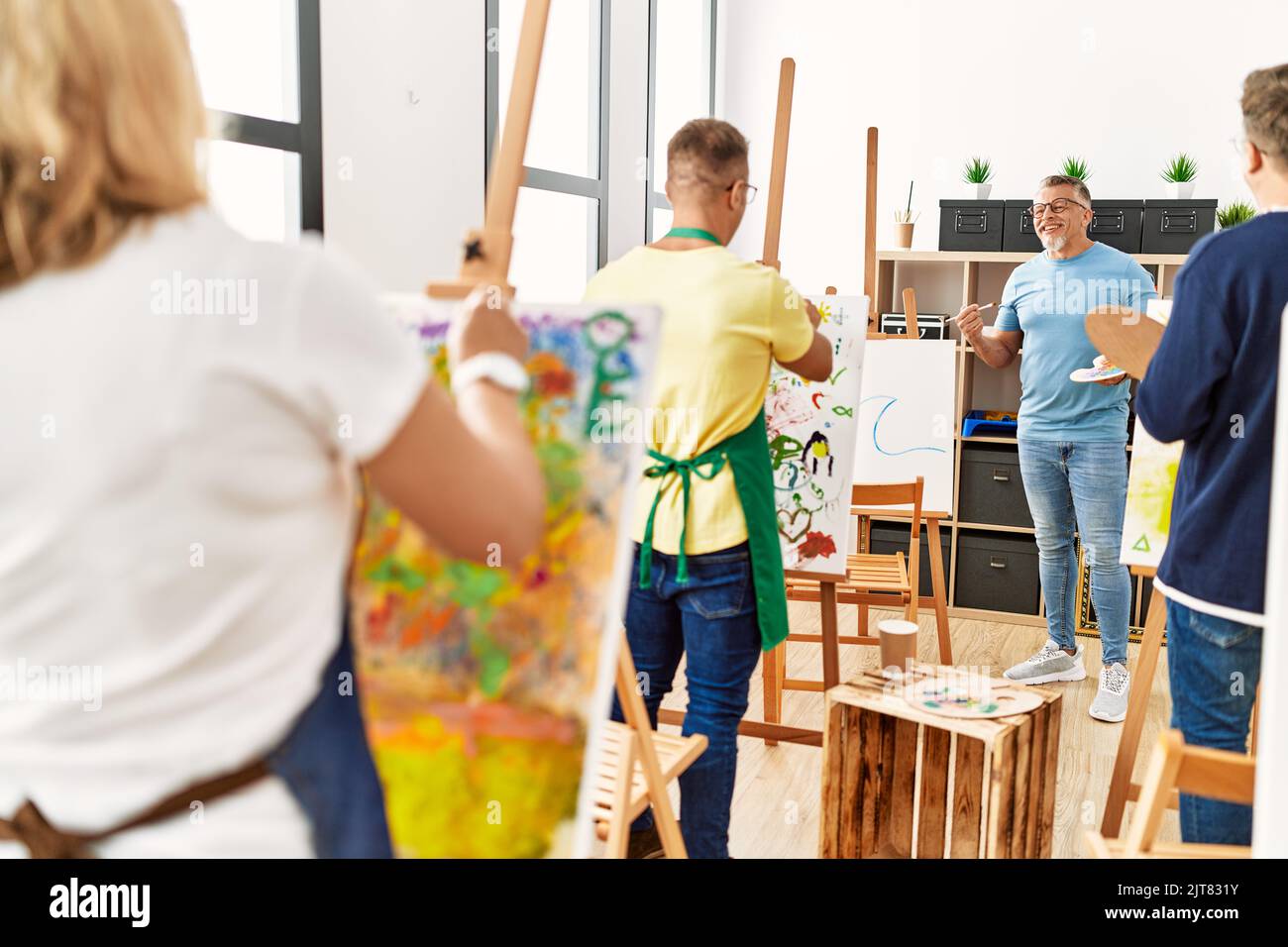 Group of middle age paint students having art class at drawing studio ...