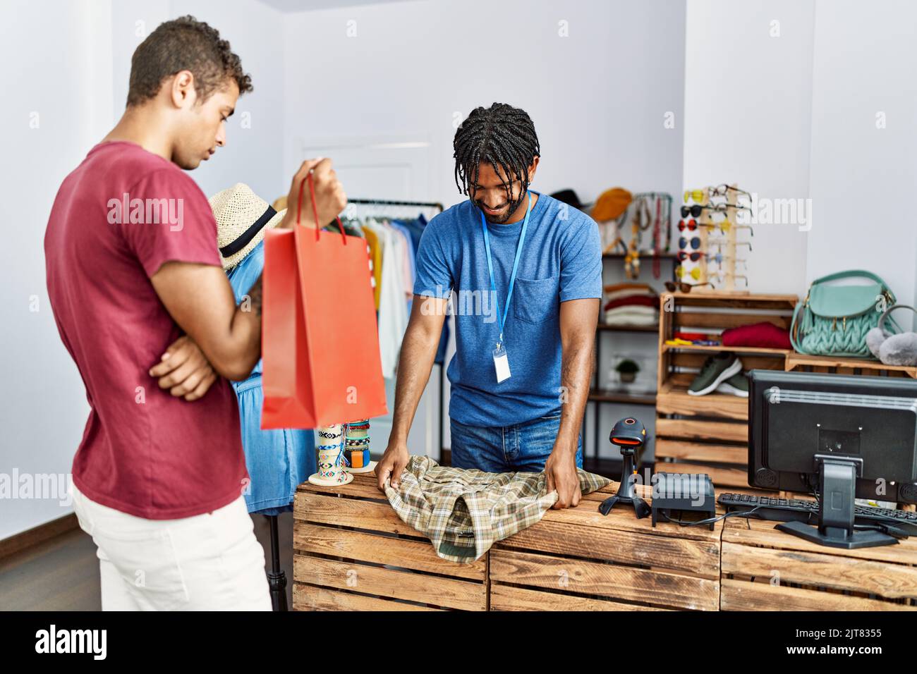 Two men shopkeeper and customer shopping at clothing store Stock Photo ...