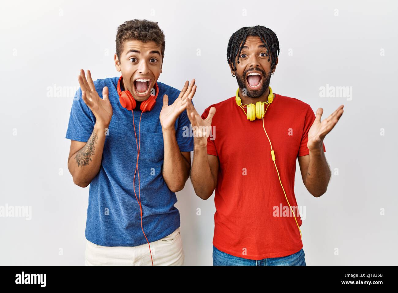 Young hispanic brothers standing over isolated background wearing ...
