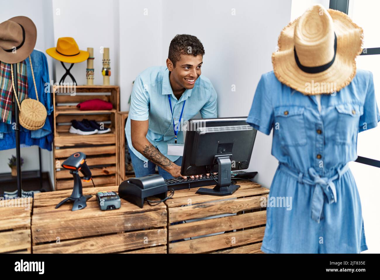 Young hispanic man working as shop assistant at retail shop Stock Photo ...