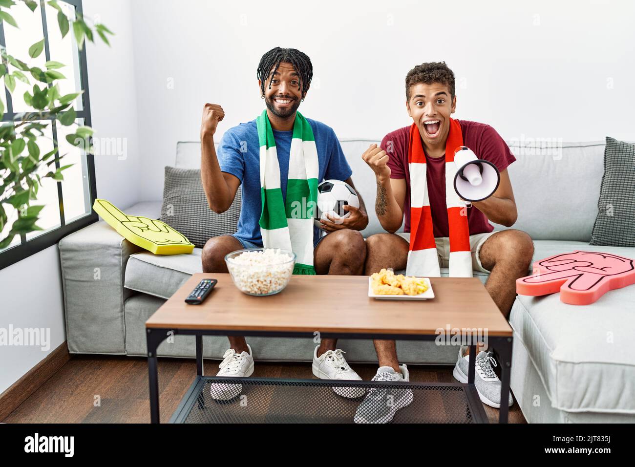 Young hispanic brothers football hooligans holding ball and megaphone ...