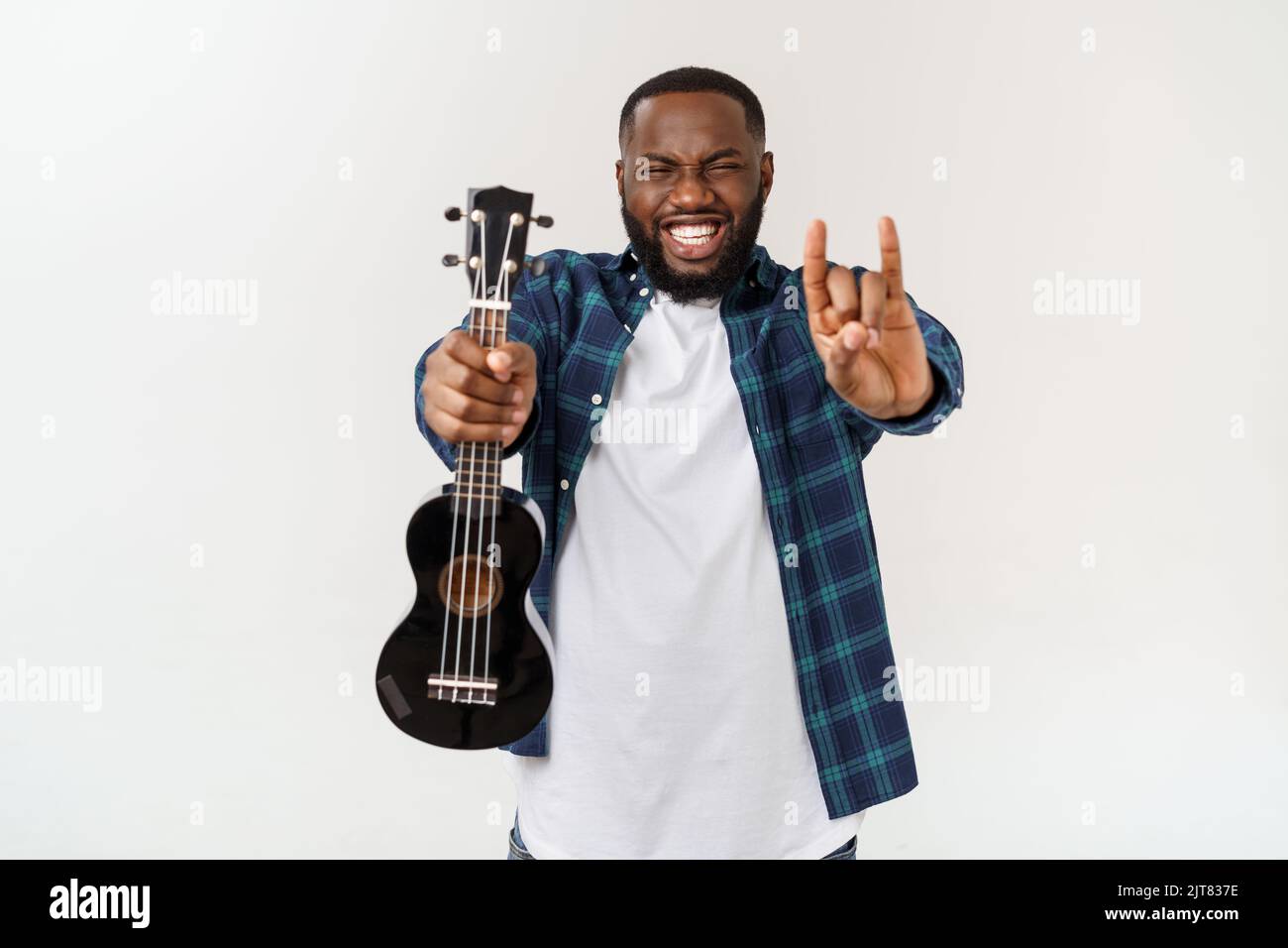 Young handsome african american man plays ukulele isolate over white ...